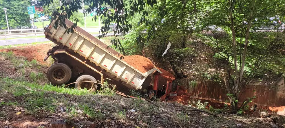 Caminhão desgovernado bate em carro parado, atinge poste de energia e cai dentro de córrego ...